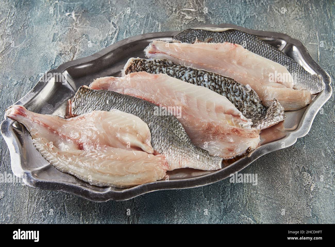 Fresh bass fish, ready to cook on tray Stock Photo - Alamy