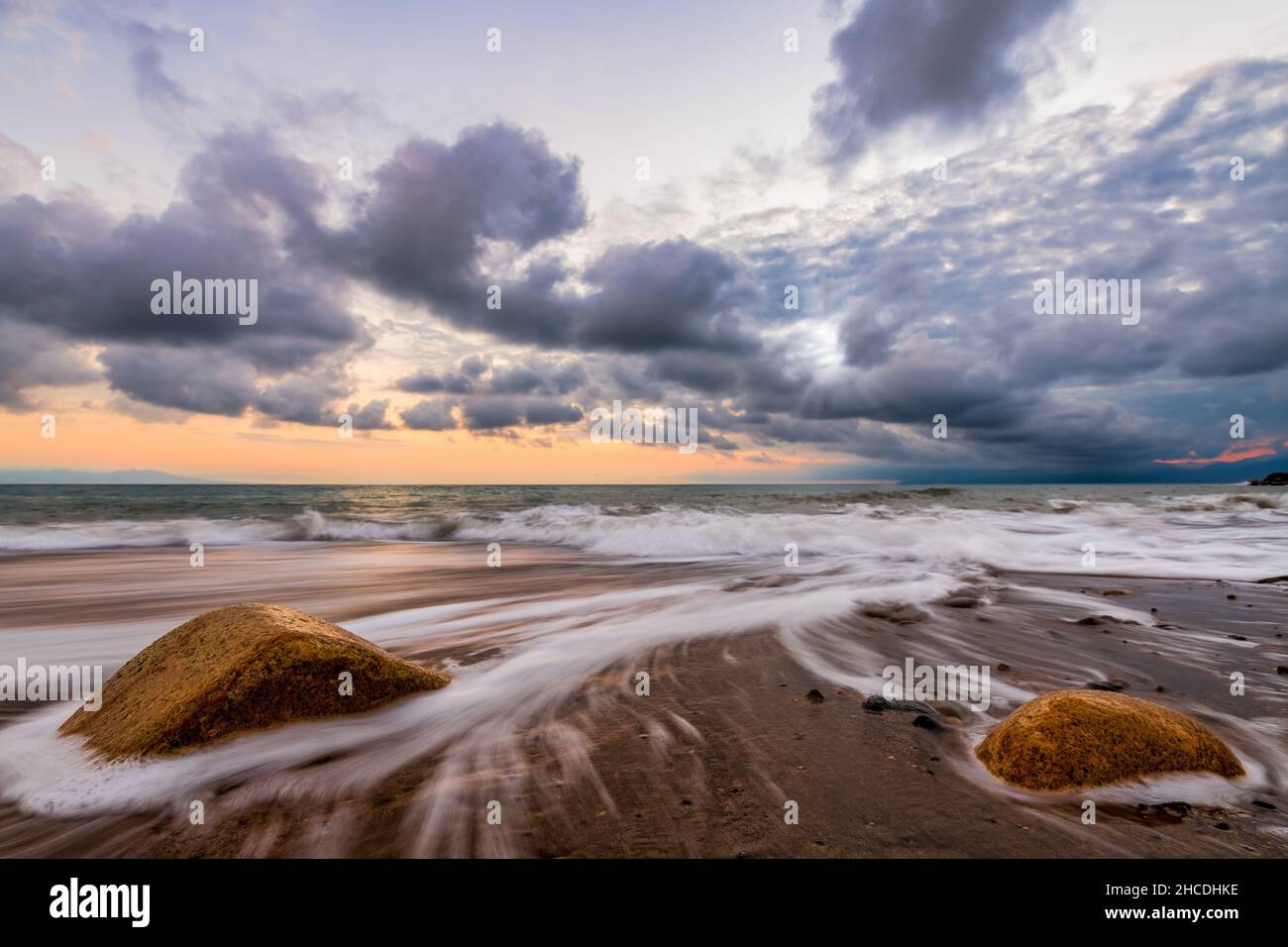 A Beautiful Ocean Sunset With a Colorful Sky As A Wave Rolls To The ...