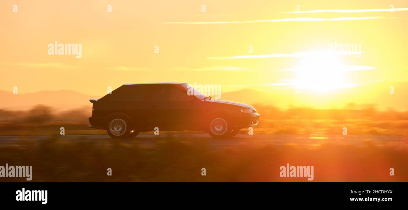 Car driving fast on intercity road at sunset. Highway traffic in ...