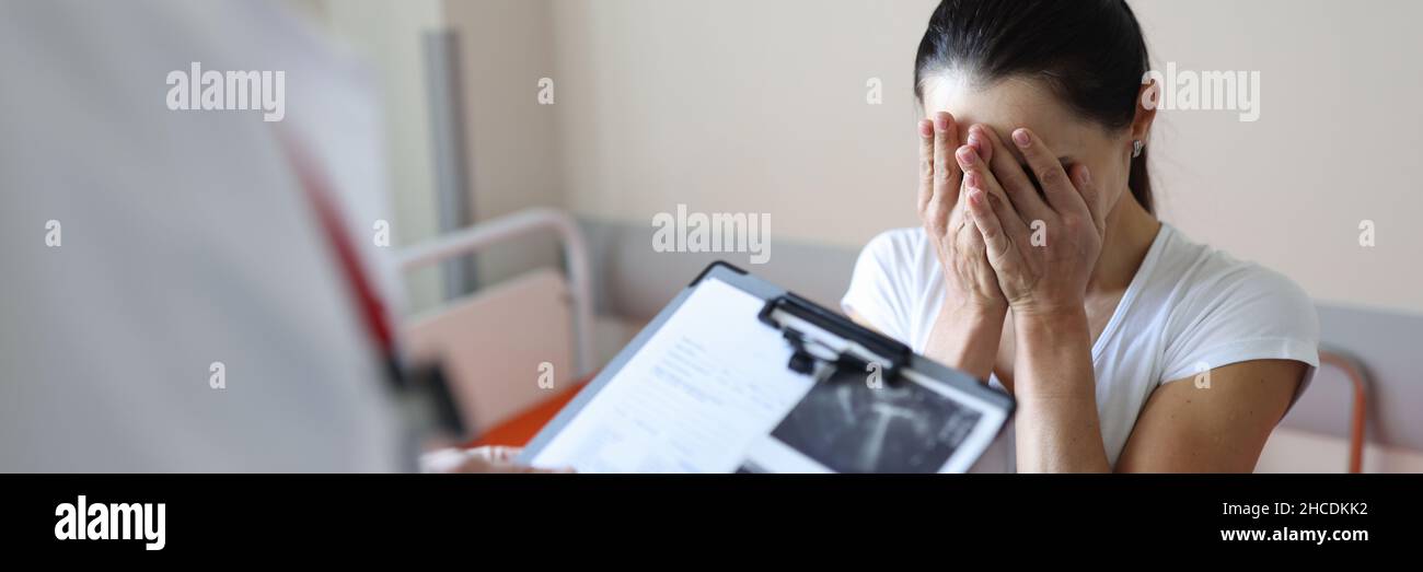 Doctor holding documents in front of crying patient in clinic Stock ...