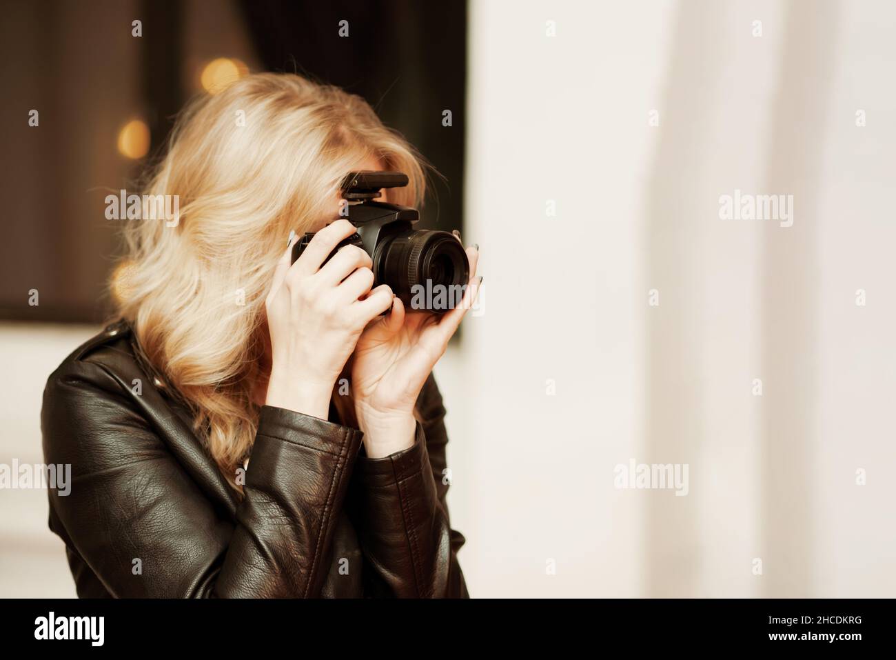 Portrait of a cute girl photographer taking pictures in a photo studio ...