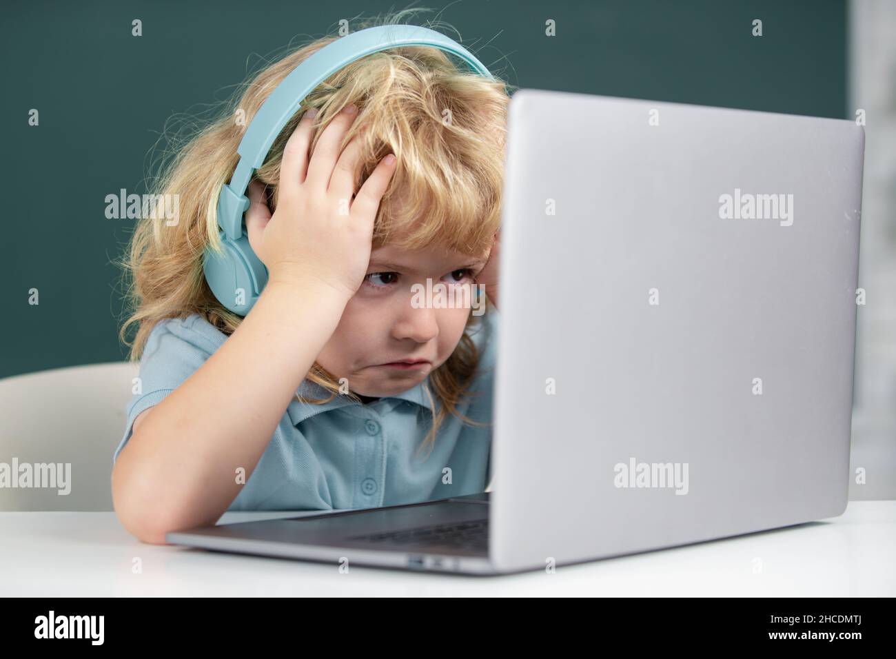 Angry sad school kid working in computer class. Little funny system ...