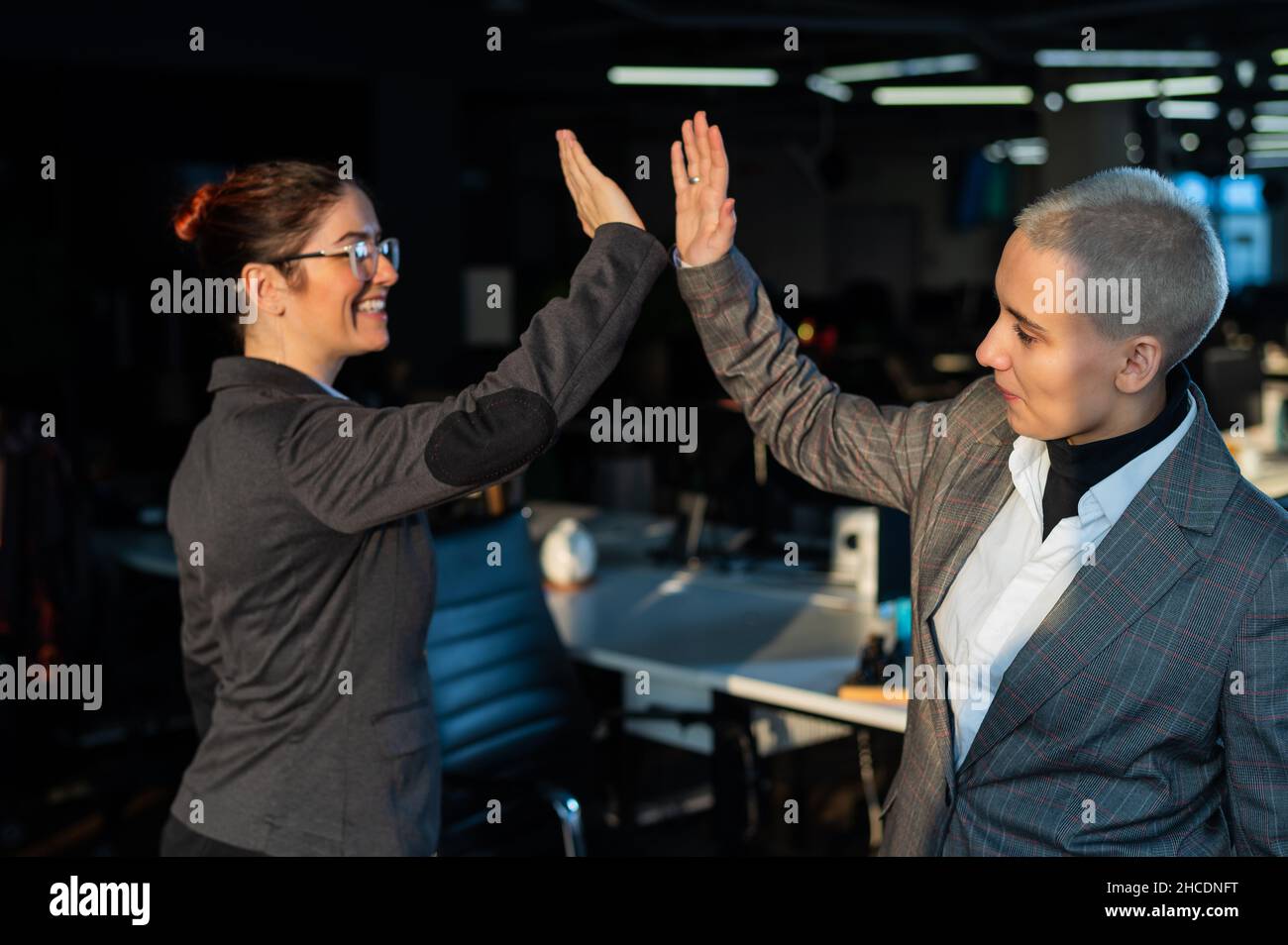 Two business women give a high five in the office Stock Photo - Alamy