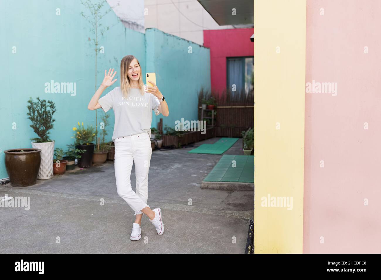 Pretty laughing caucasian woman with smartphone has good time outdoor. portrait of trendy ...