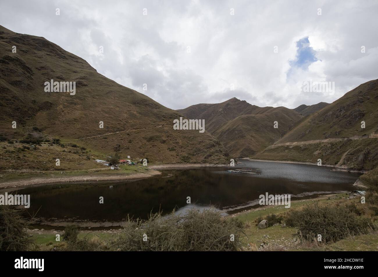 Small dark lake surrounded by mountains and hills in Peru Stock Photo ...
