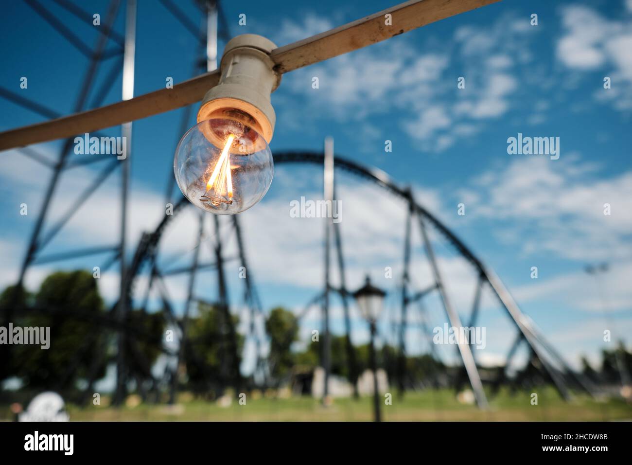 Closeup of a single lightbulb hanging vertically along a horizontal ...