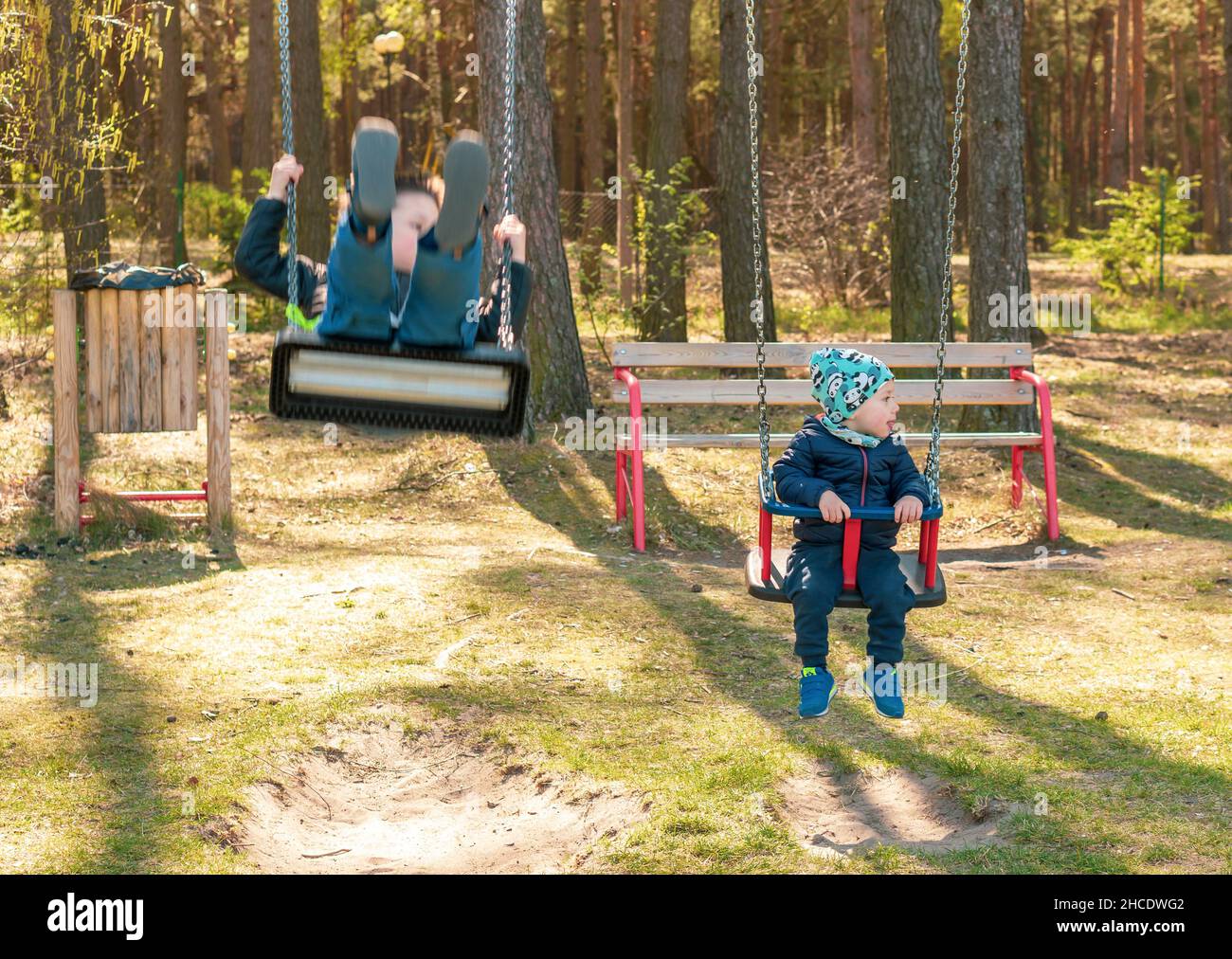 Two children sitting on a swing set at a playground close by the Deczno ...