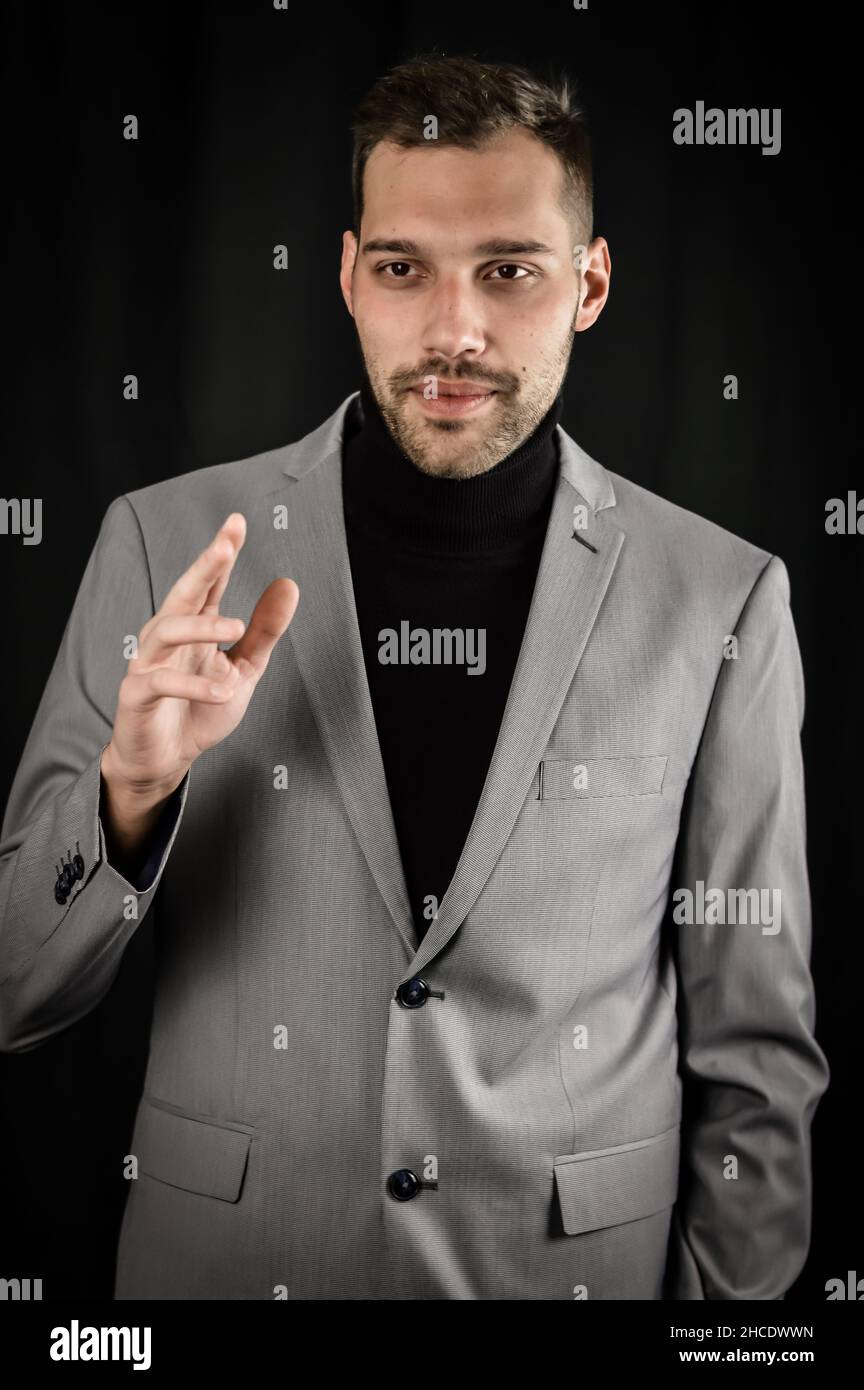 portrait of a young businessman in a gray business suit making a ...