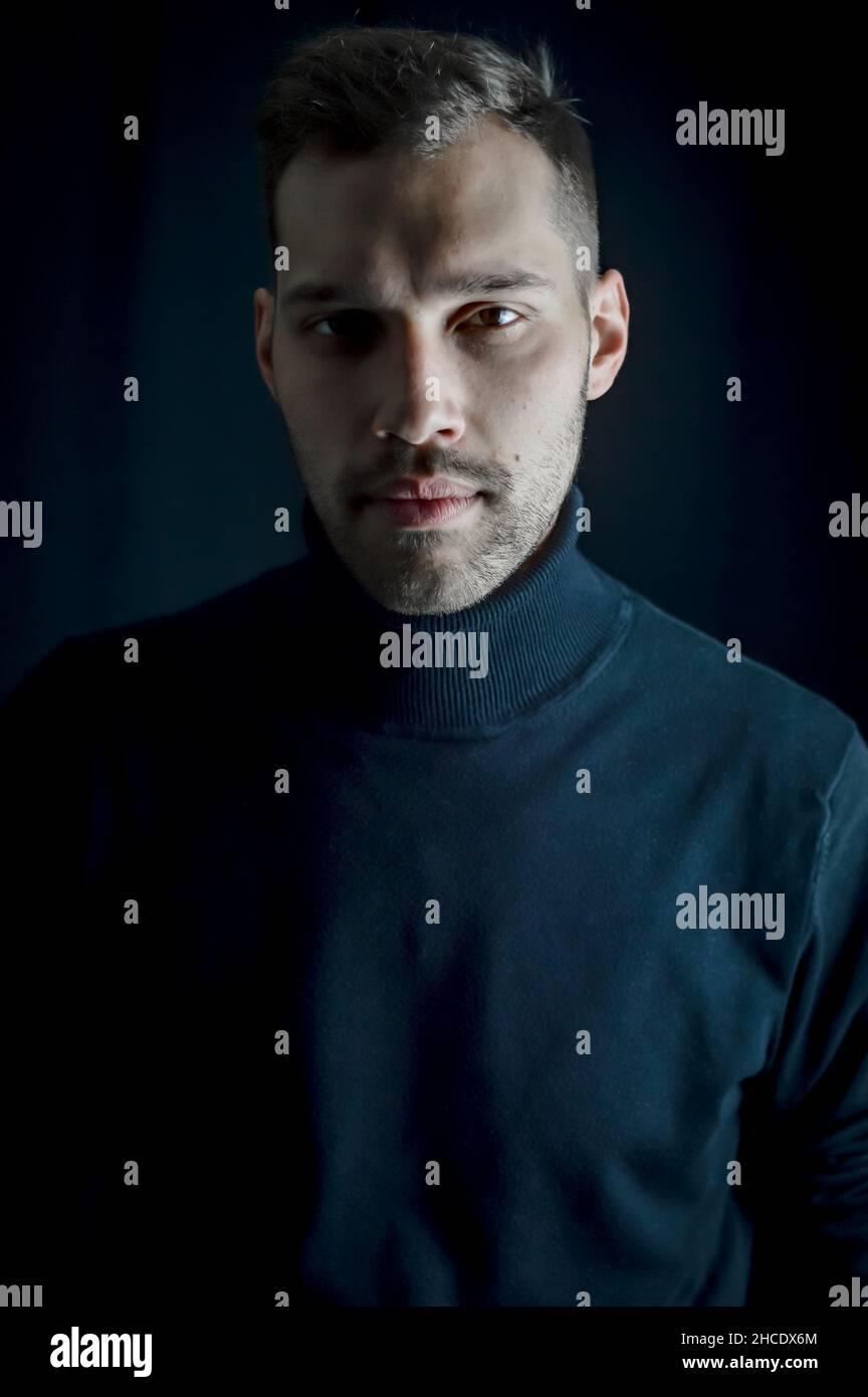 portrait of a young man in a black turtleneck with an intense and ...