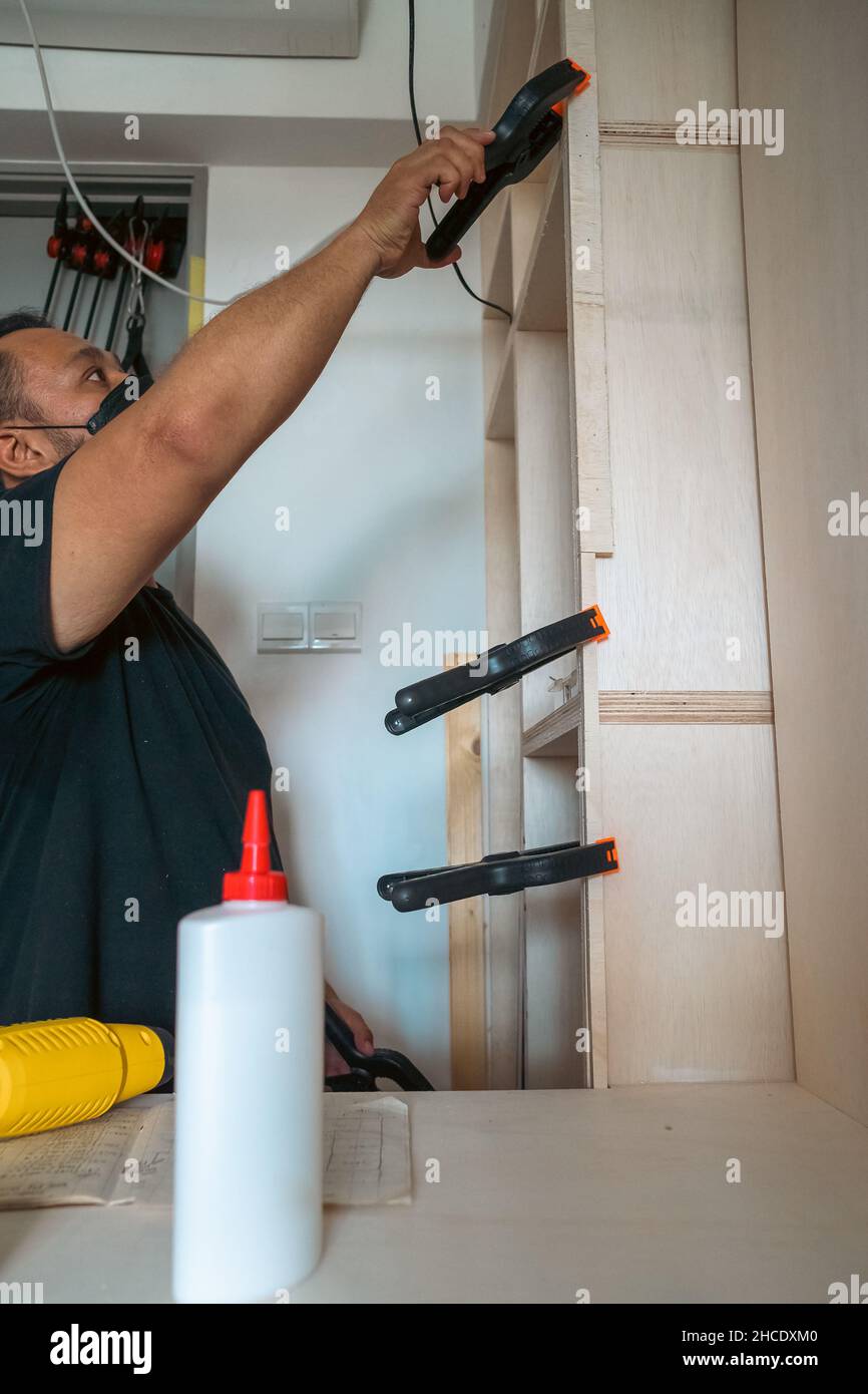 Man using clamps to hold workpiece gluing. DIY project at home Stock ...