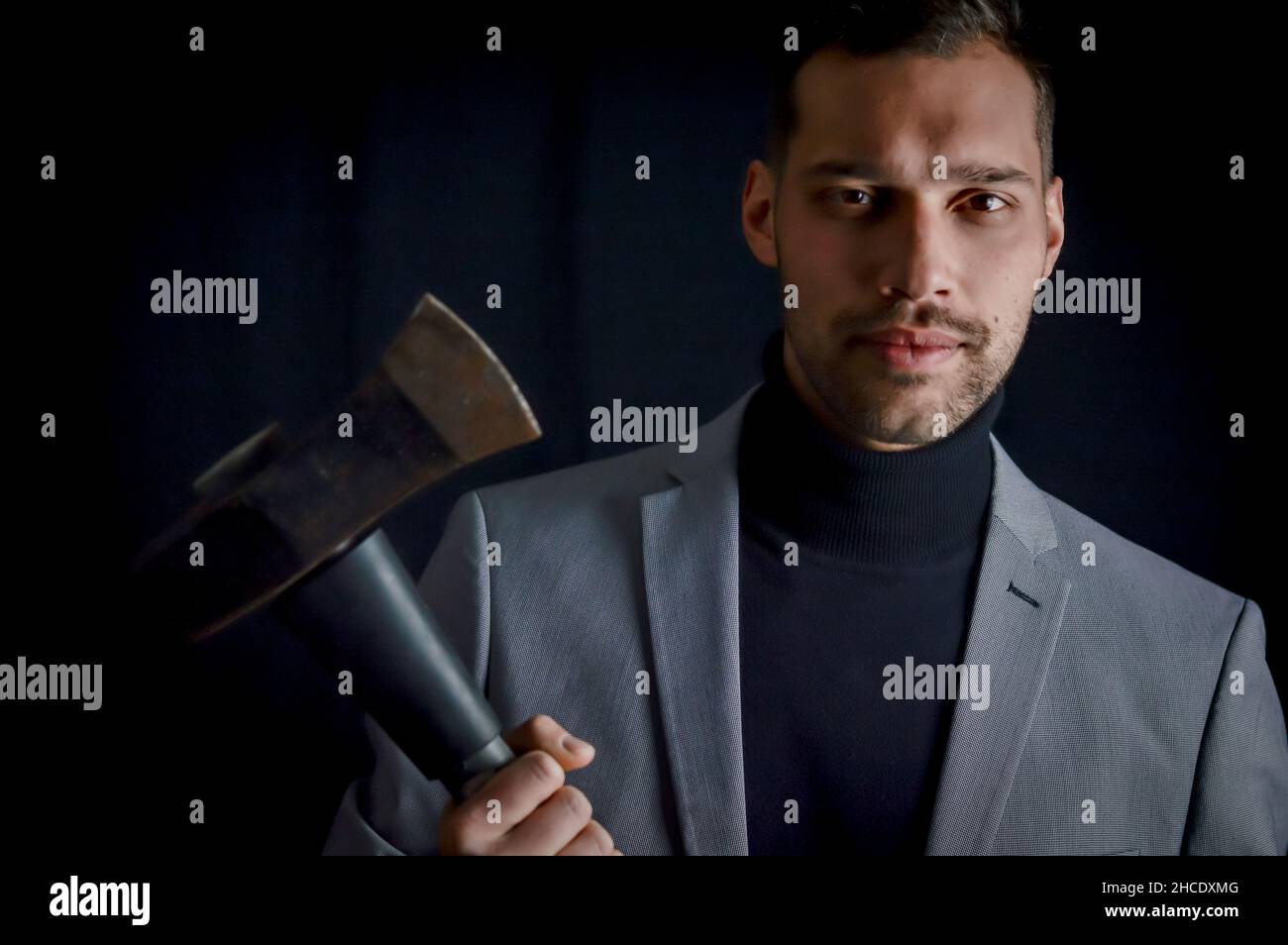 young businessman with gray suit holding an ax in his hand and has a ...