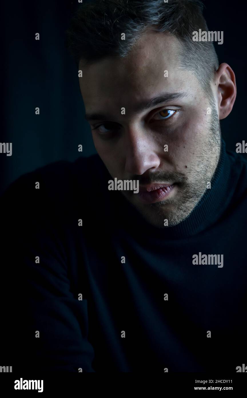portrait of a young man in a black turtleneck with an intense and ...