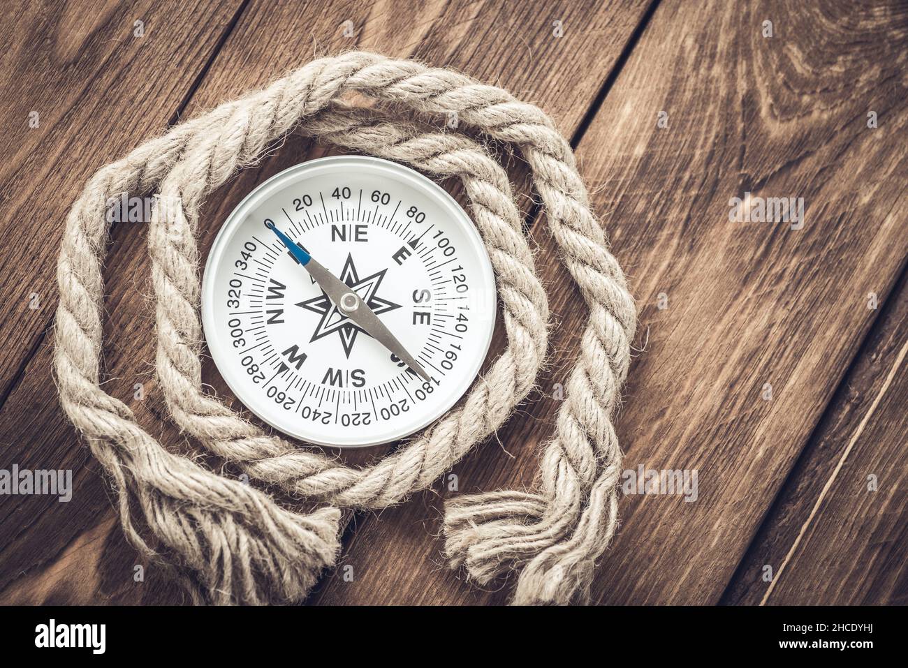 Compass and rope on wooden texture background Stock Photo - Alamy