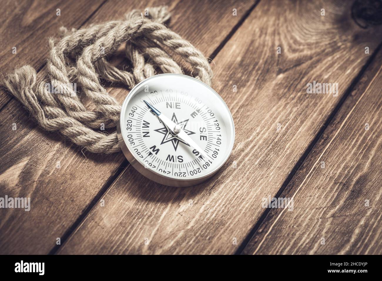 Compass and rope on wooden texture background Stock Photo - Alamy