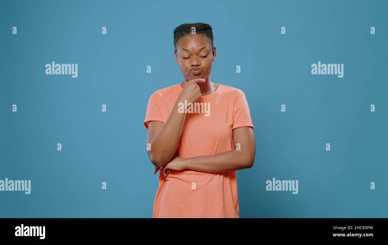 Pensive woman doing thinking face with hand on chin, showing confused ...