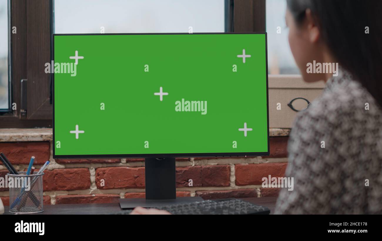 Close up of worker using computer with horizontal green screen in ...