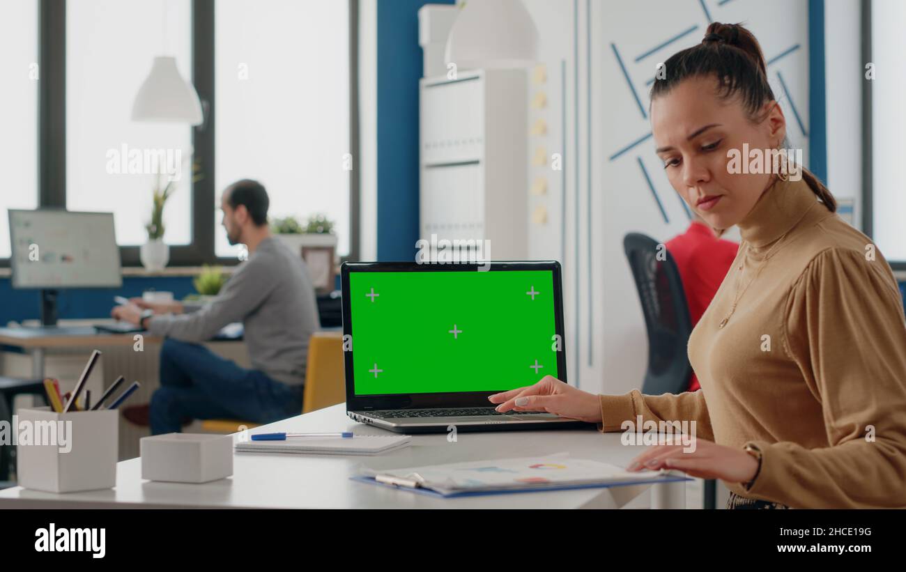 Person working with green screen on laptop in business office. Woman ...