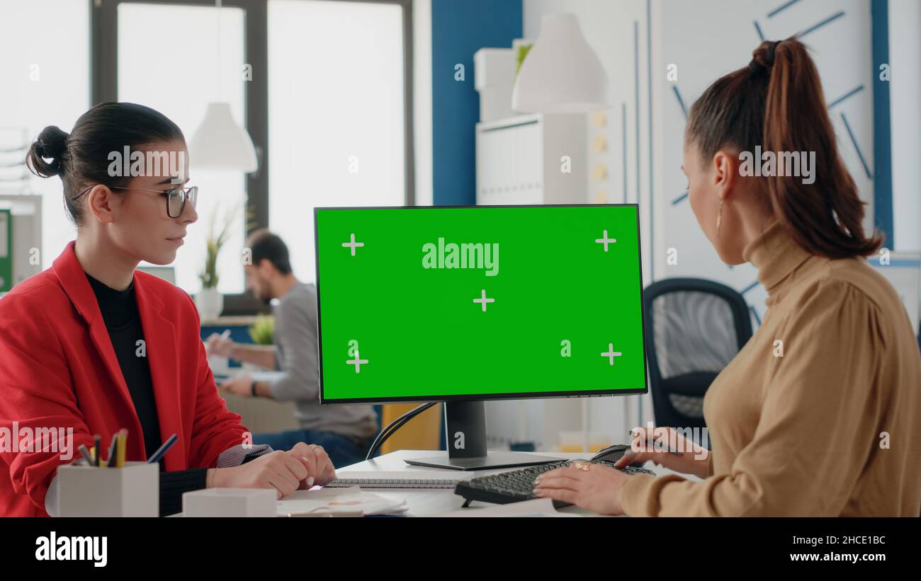 Coworkers working with green screen on monitor for startup business ...