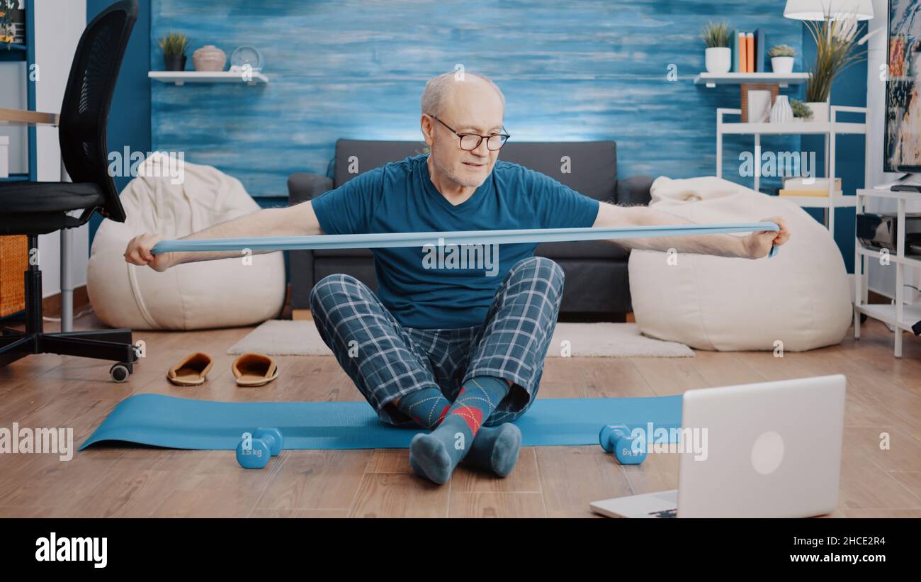 Senior person pulling flexible resistance band to exercise while ...