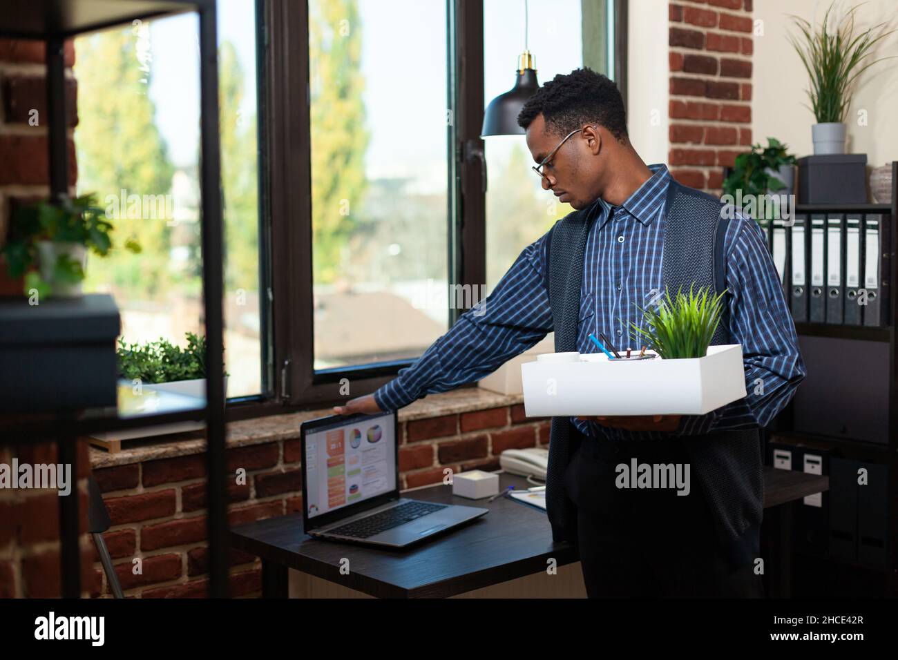 Laid off marketing specialist closing laptop with business analytics ...