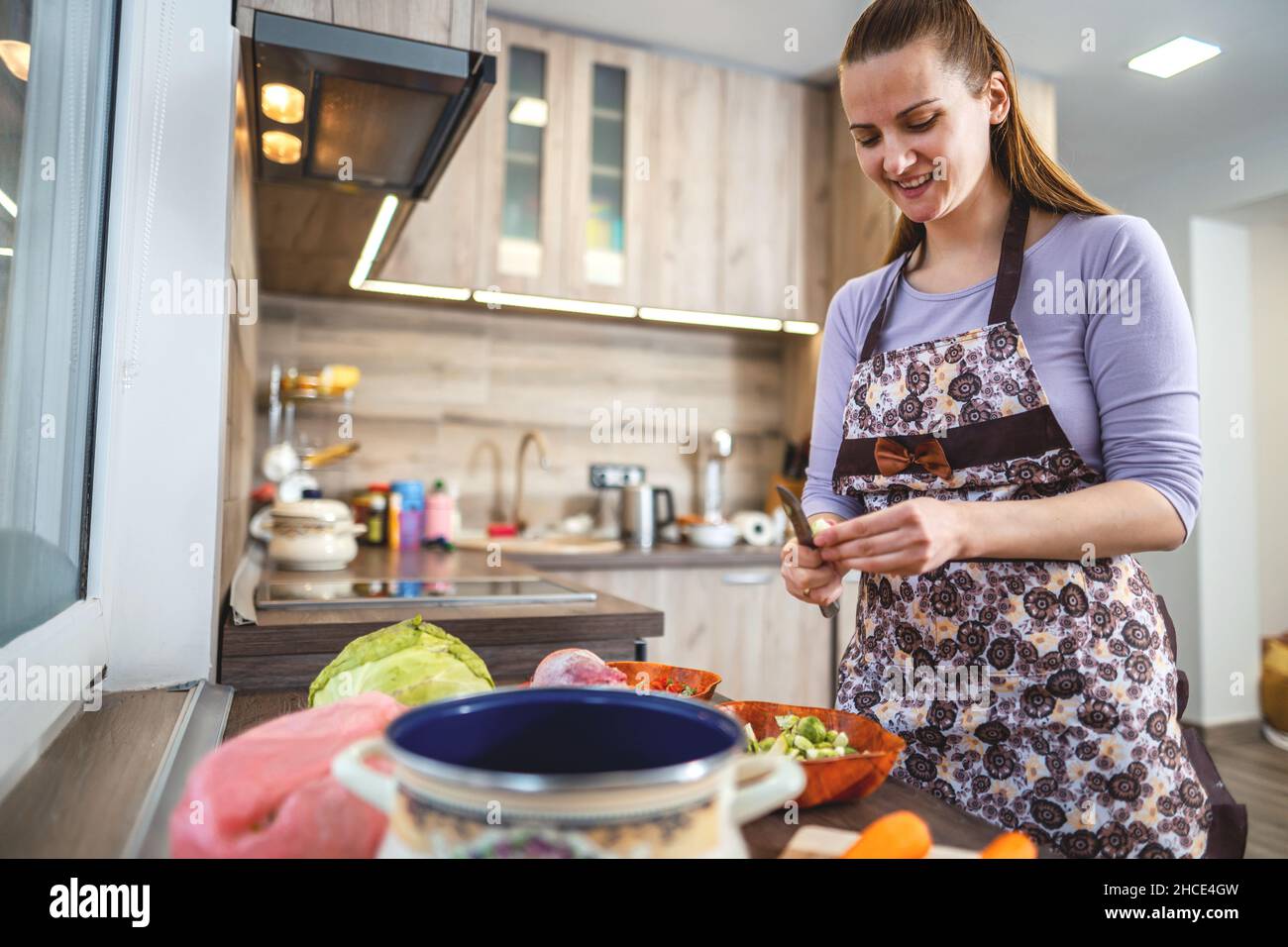 Caucasian female making food in a kitchen Stock Photo - Alamy