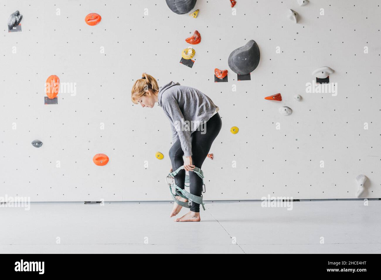 Woman putting climbing harness hi-res stock photography and images - Alamy