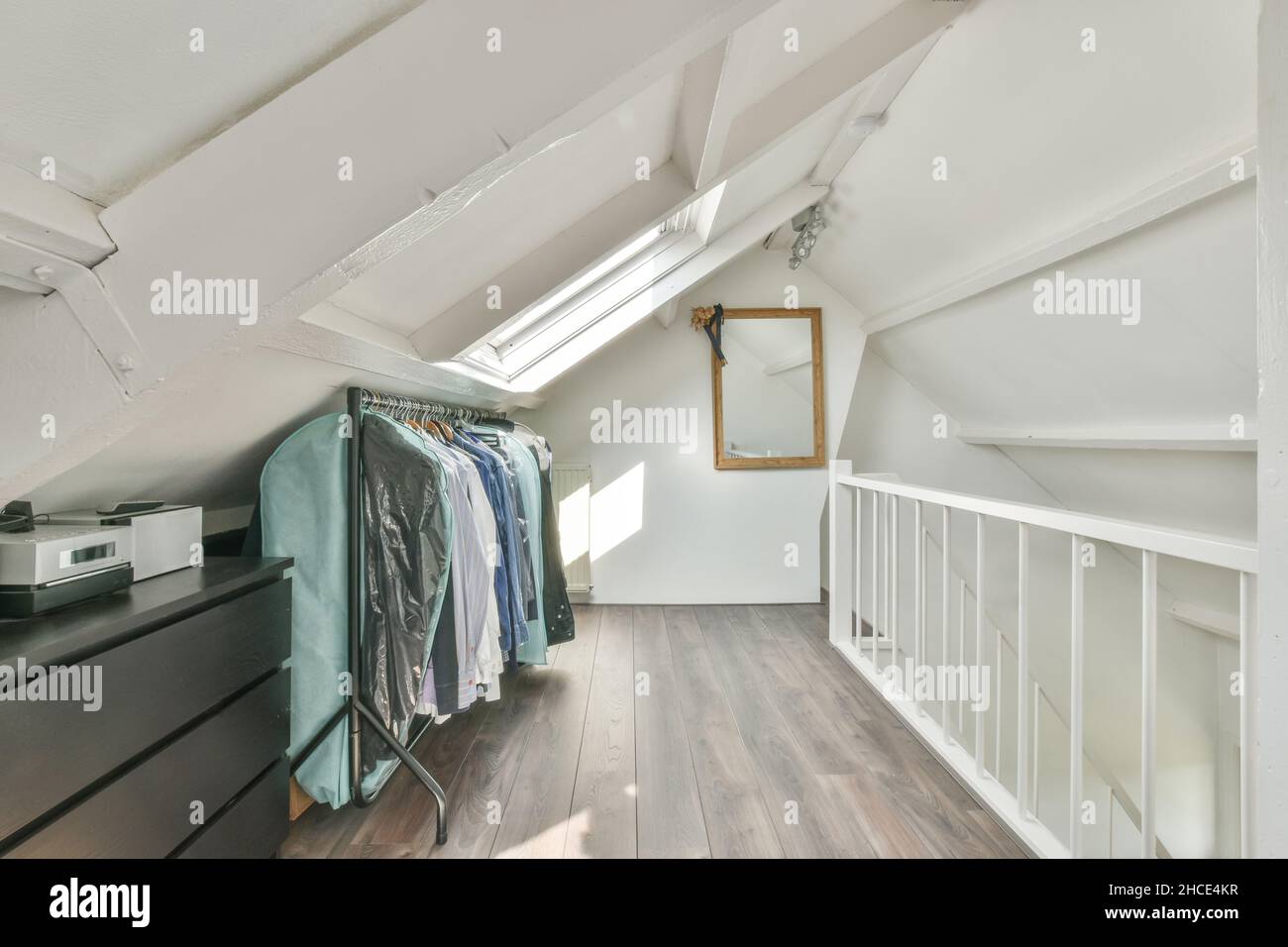 Interior of closet room with clothes hanging on racks and wide window ...