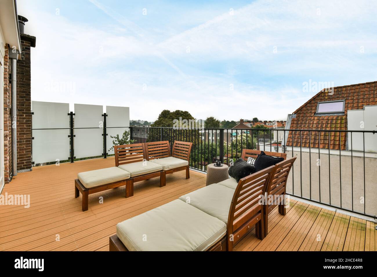 Wooden bench with soft seats placed on terrace on roof of modern ...