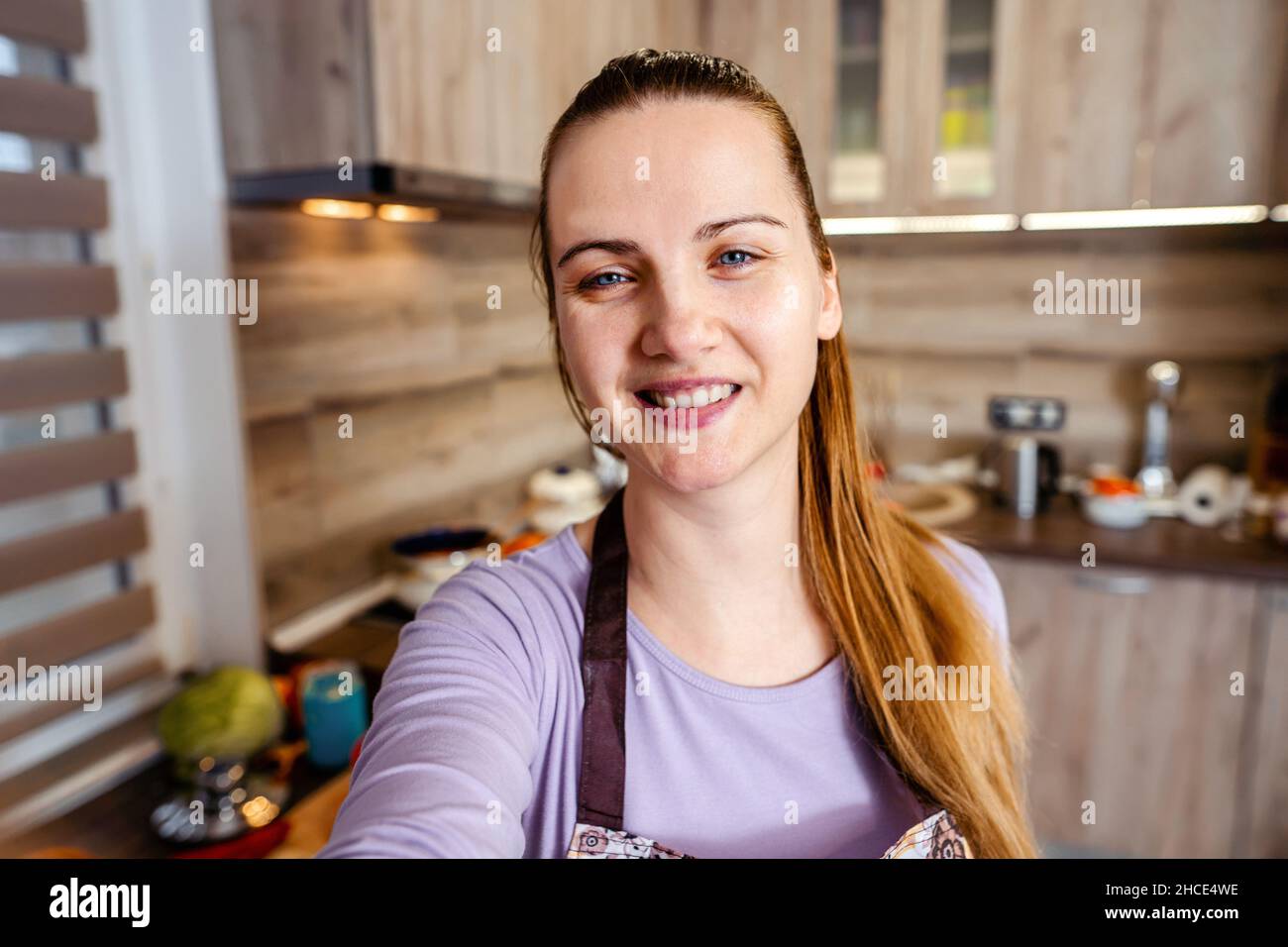 Caucasian female making food in a kitchen Stock Photo - Alamy
