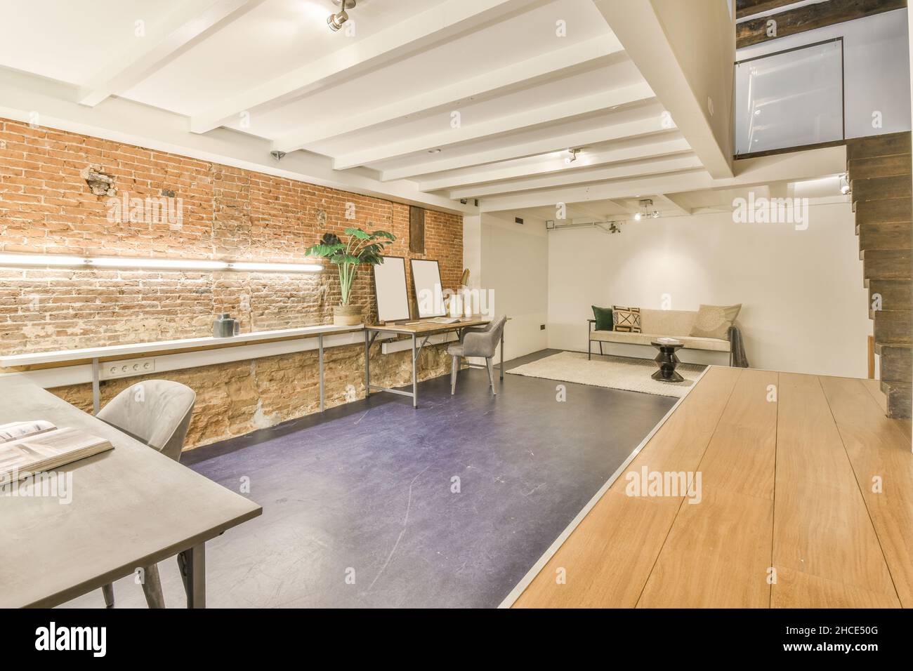 Stylish study room interior furnished with desk and comfortable sofa ...