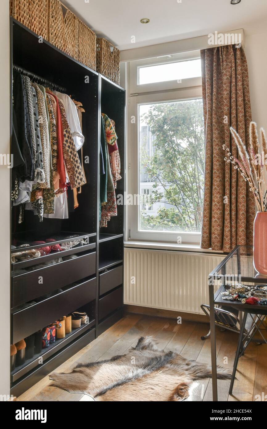 Built in wardrobe with assorted colorful clothes placed in living room ...