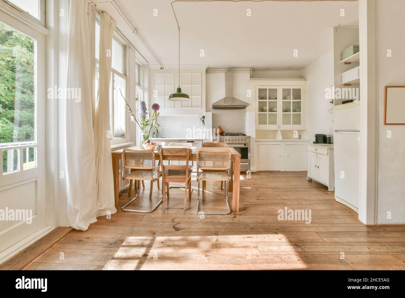 Interior of light modern kitchen with table and chairs against ...