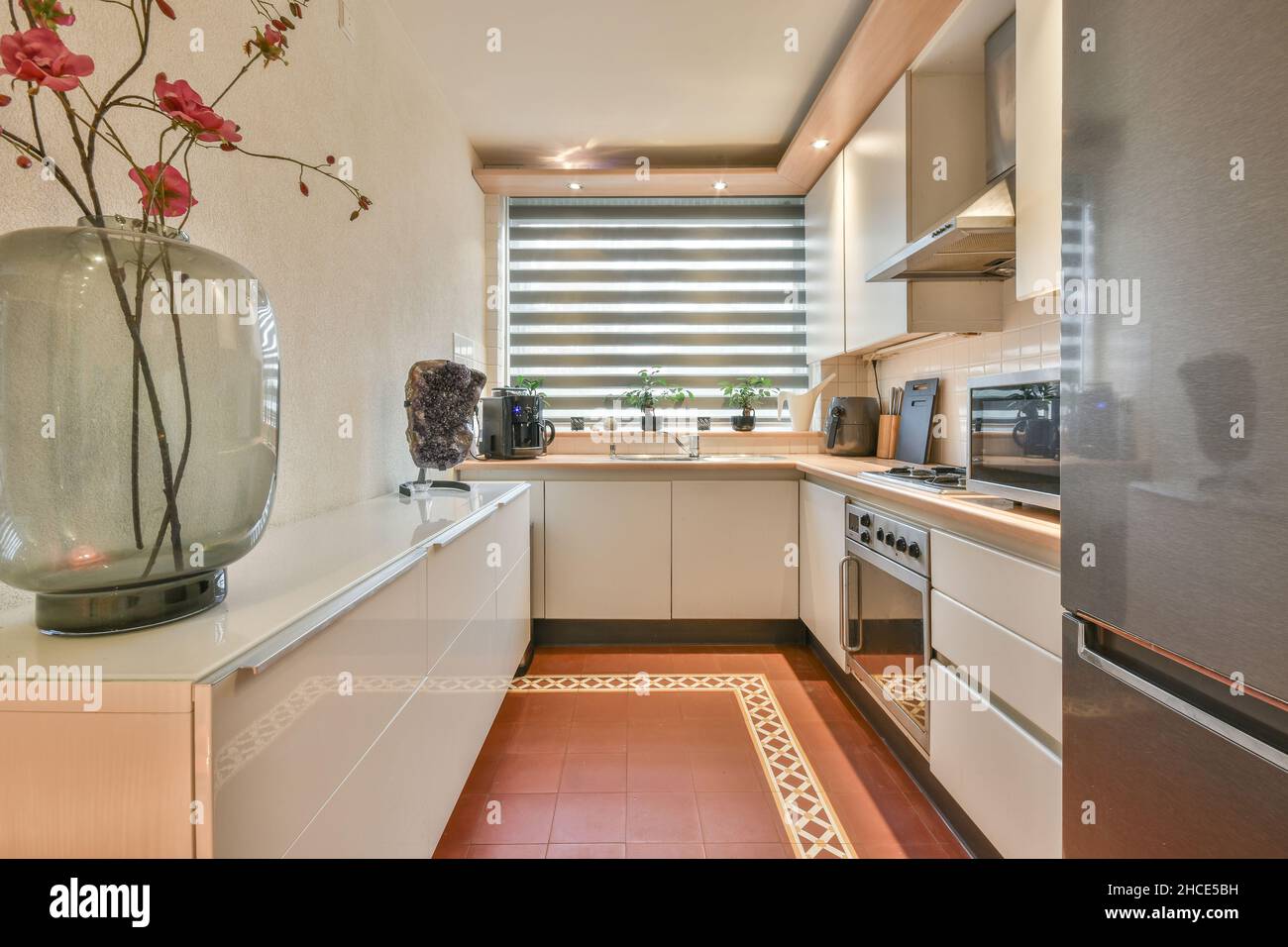 Interior of contemporary kitchen with cabinets and counter opposite ...