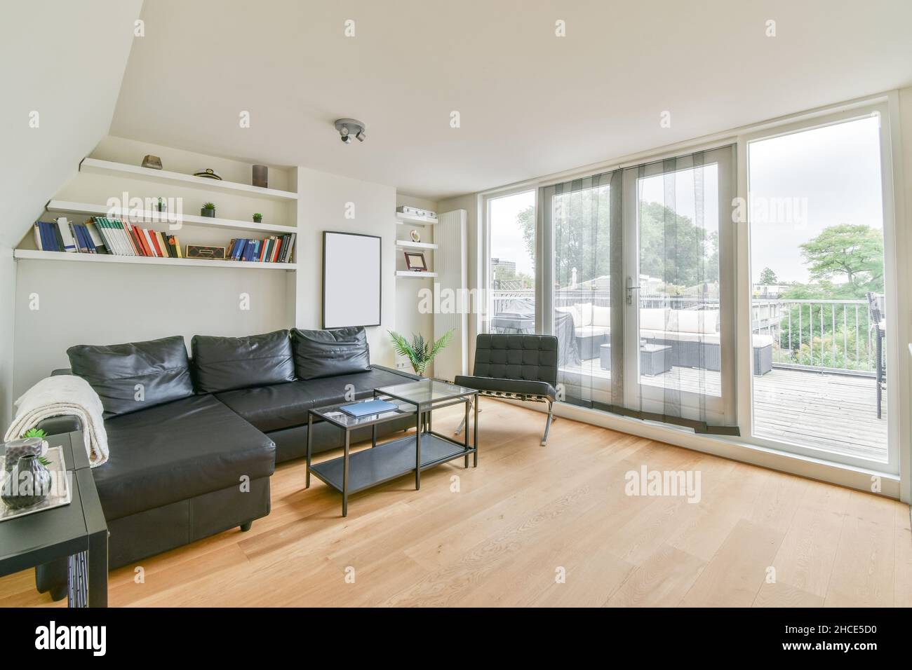 Interior of contemporary sitting room with black leather couch and ...