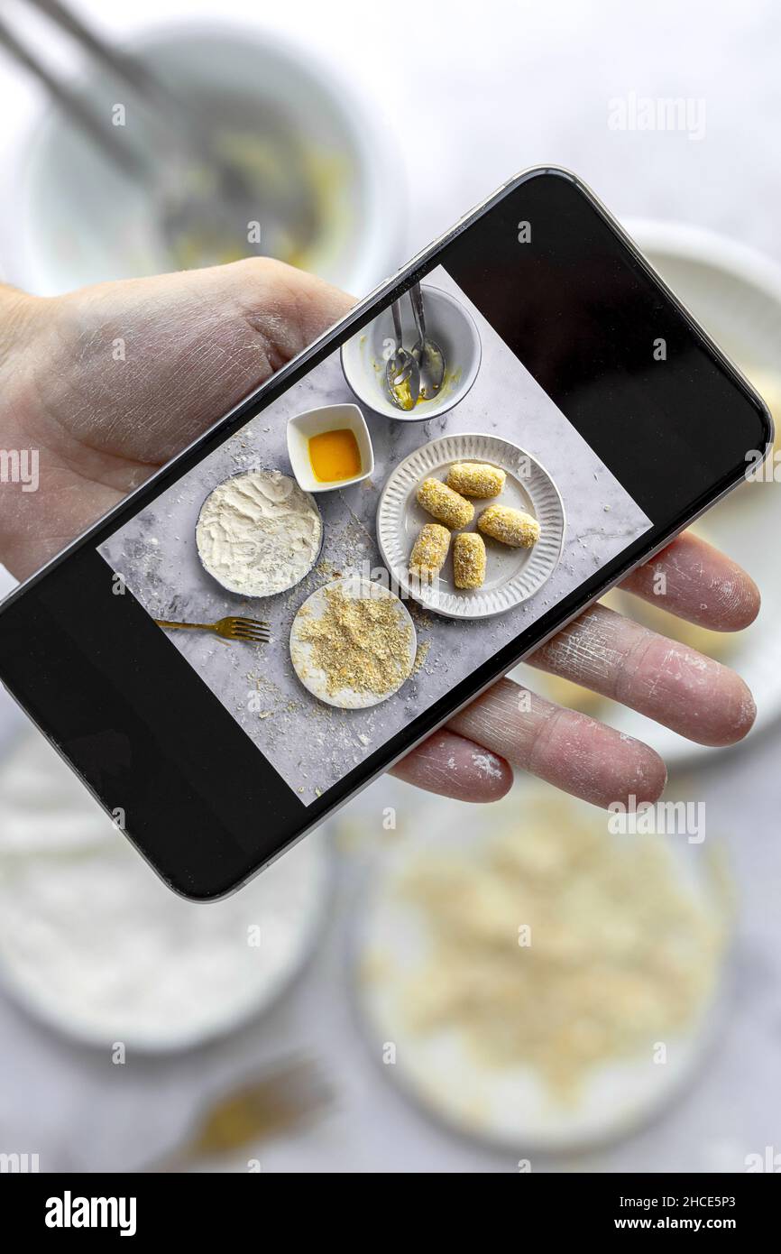 From above of crop unrecognizable person showing smartphone with photo ...