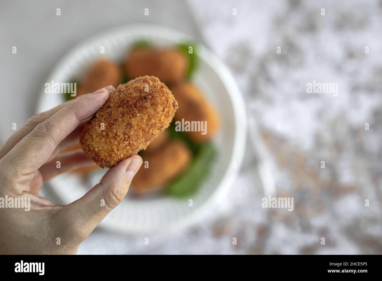 Top view of crop anonymous chef demonstrating deep fried breaded potato ...