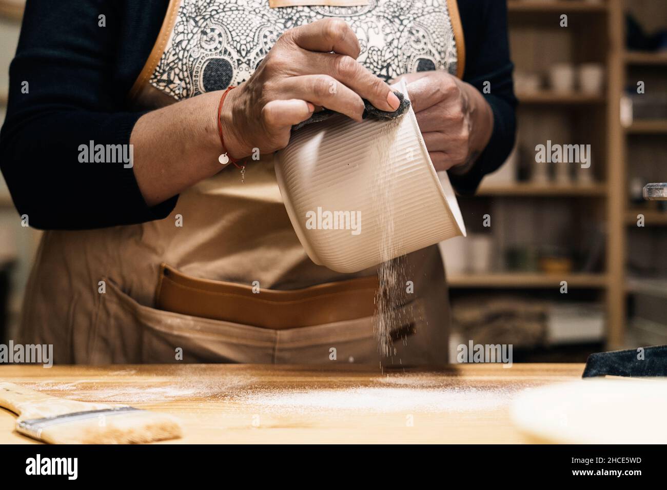 Crop unrecognizable female craftsWoman wearing apron making clay pot ...