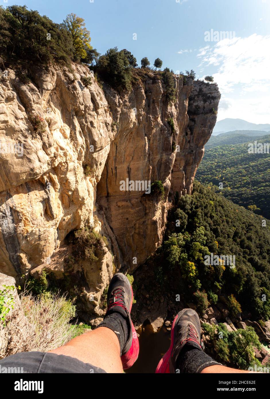Crop anonymous male traveler admiring scenery of steep rocky cliff in ...