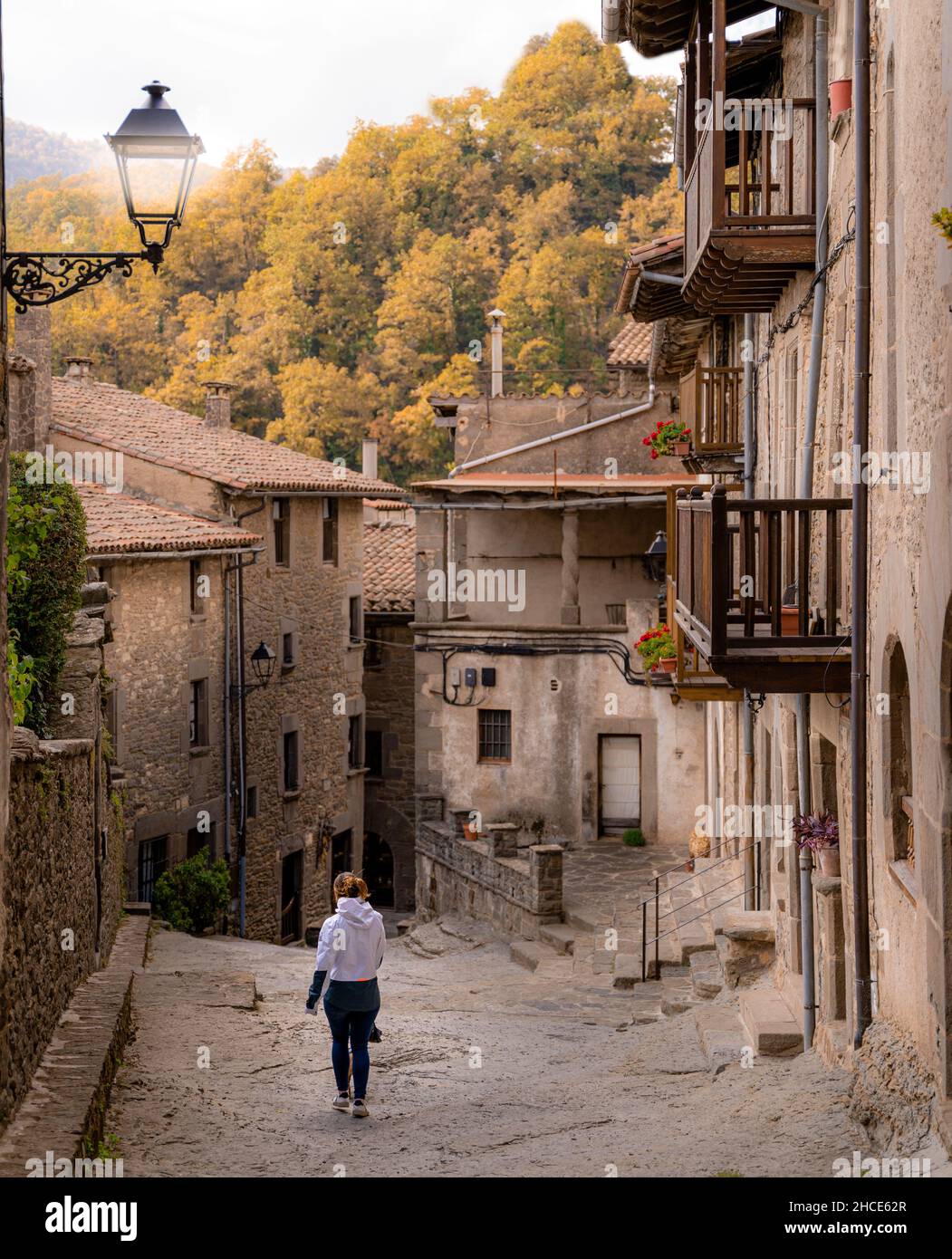 Back view full body of anonymous female strolling on stone walkway ...