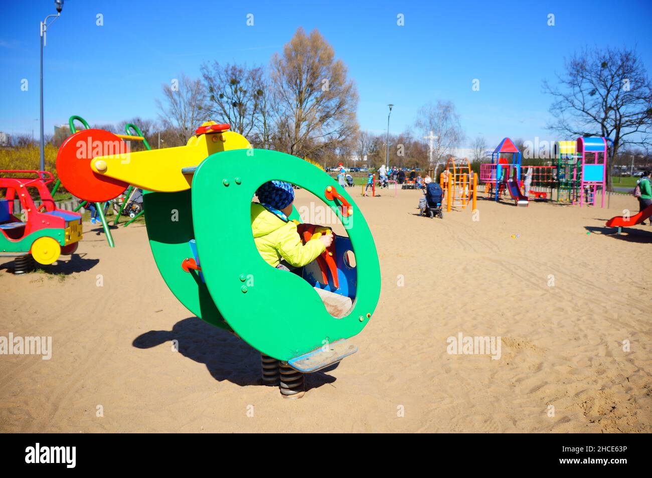 Child boy sitting in helicopter-shaped swing equipment in the Jan Pawla ...