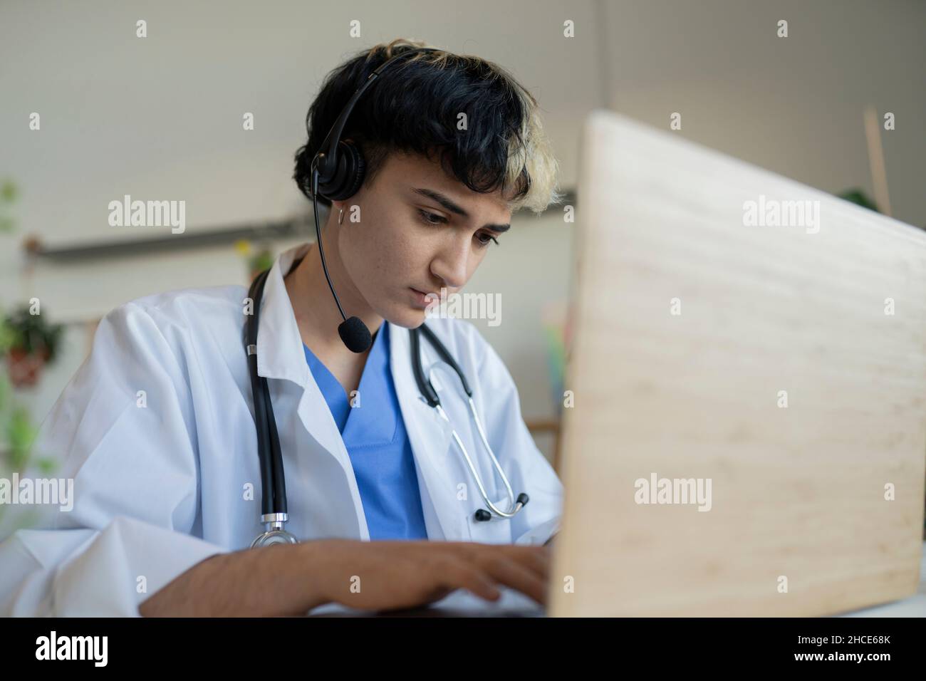 Focused female medical operator with headset in uniform and stethoscope ...