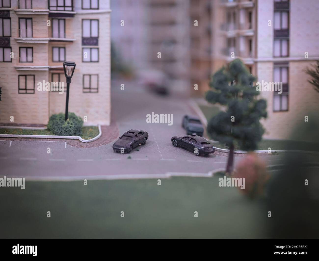 Miniature model of street with tiny cars on the road near a residential ...