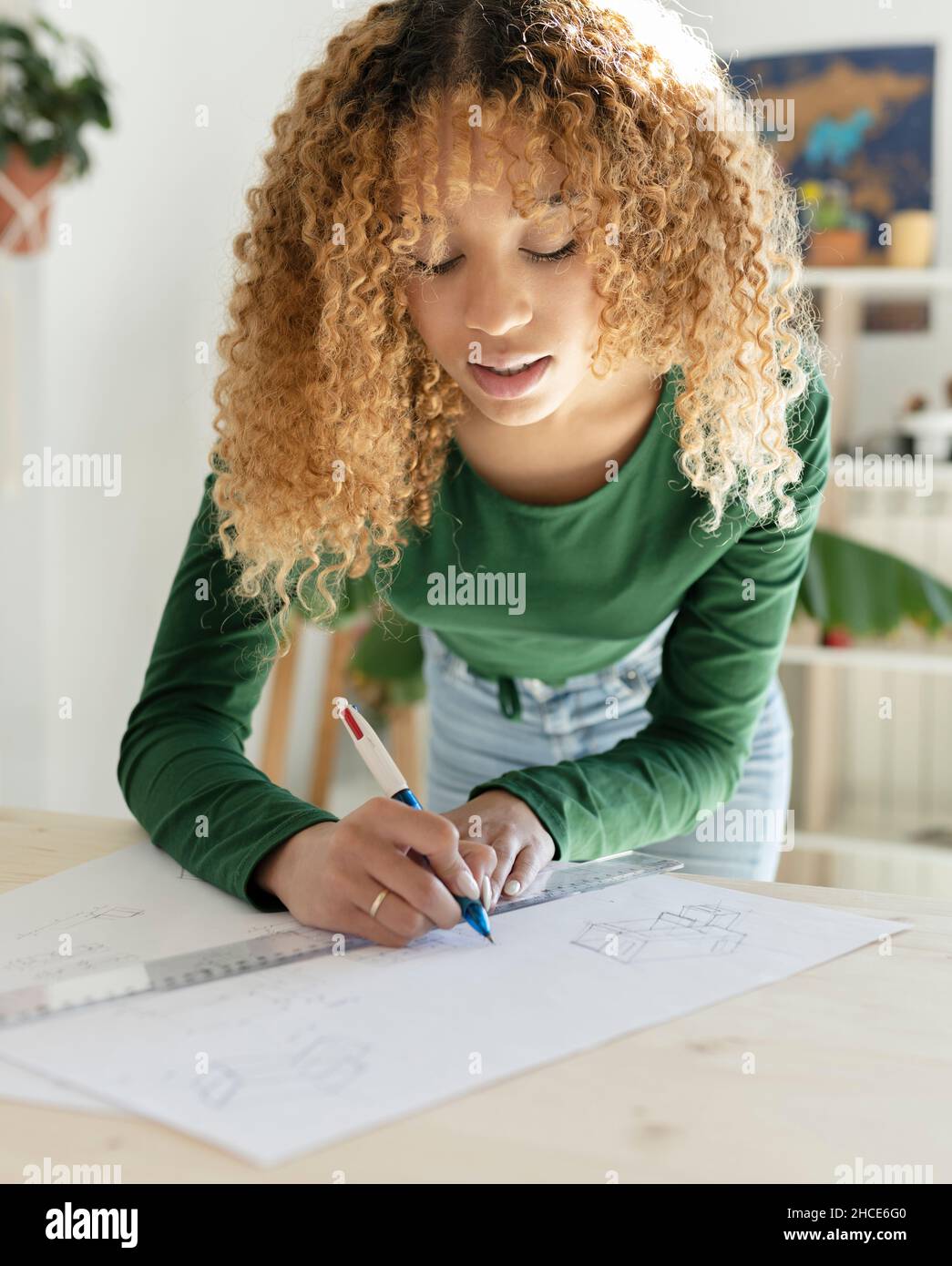 Concentrated African American female designer making drawing sketches ...