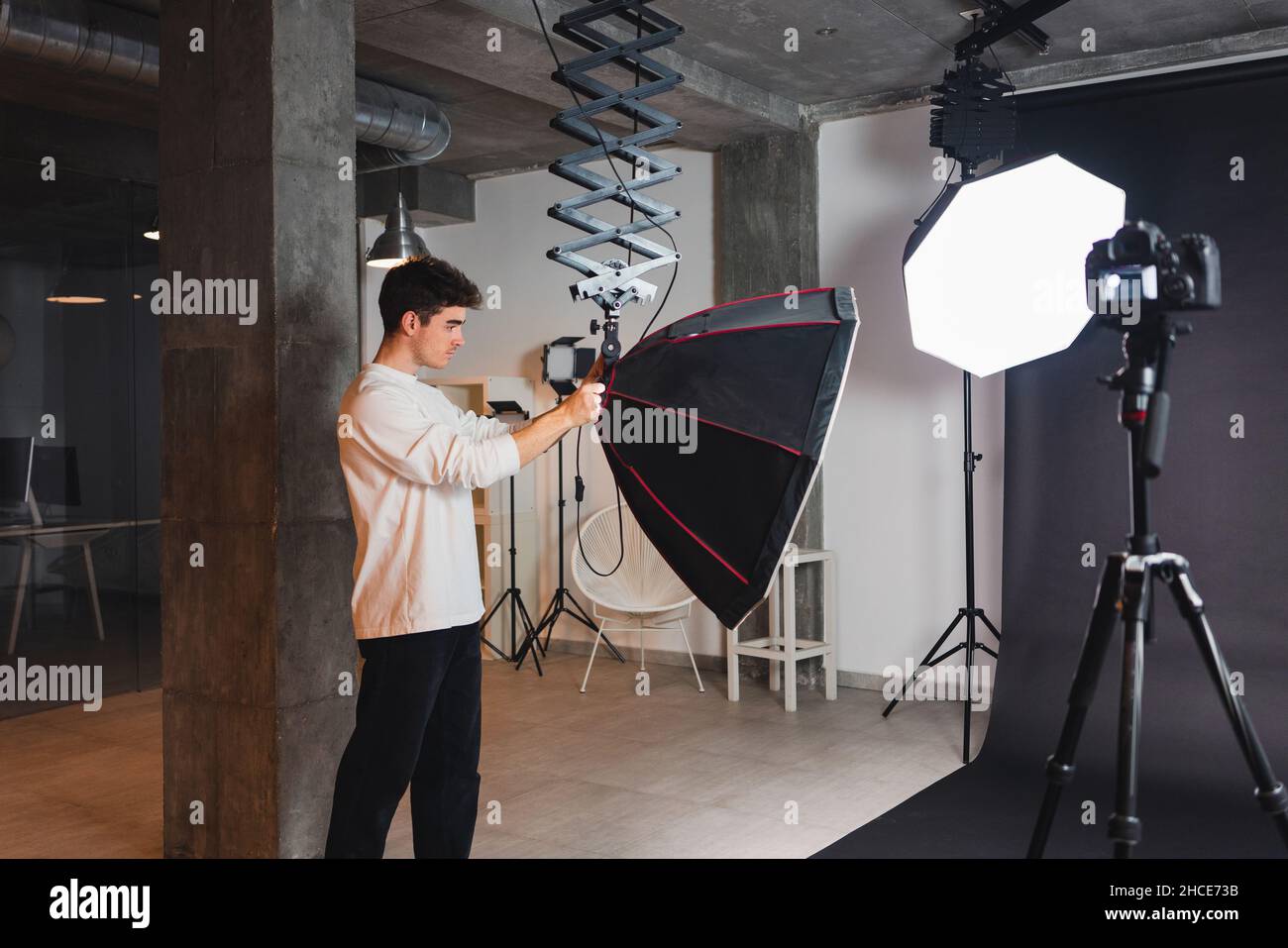 Male standing and turning on modern octabox light in professional photo ...