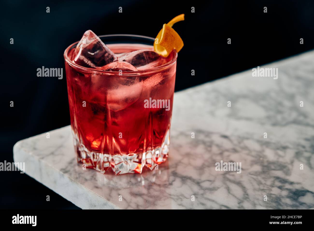 Glass of refreshing Negroni cocktail with bitter flavor and ice ...