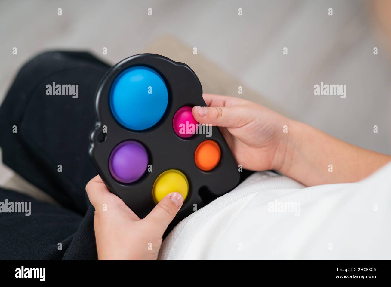 Faceless caucasian little boy plays simple dimple and relieves stress ...