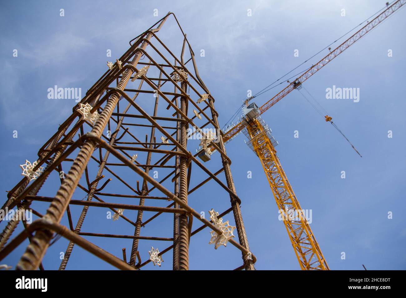 Reinforced concrete structure and tower crane against the blue sky ...