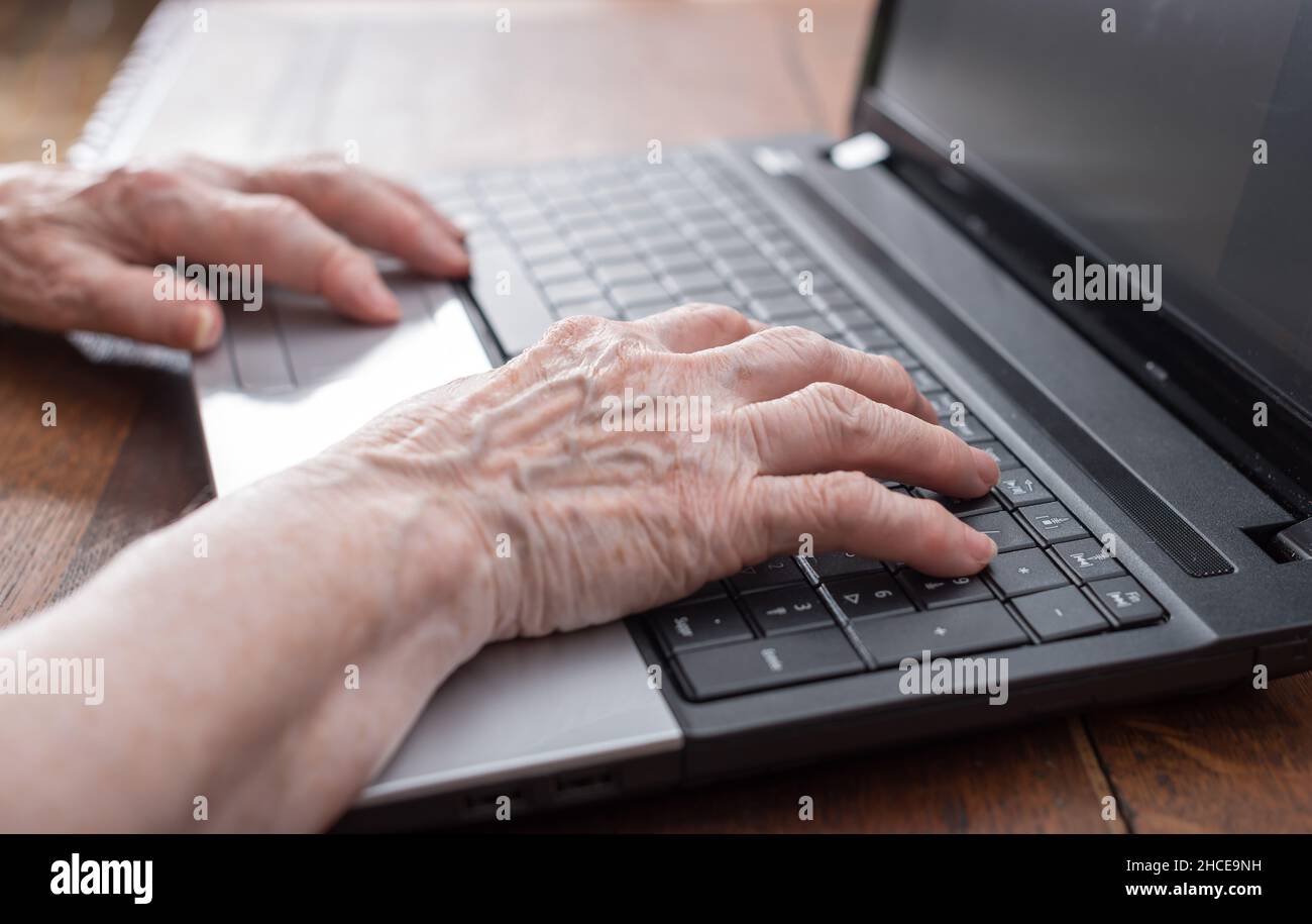 Old woman hands typing on a laptop keyboard Stock Photo - Alamy