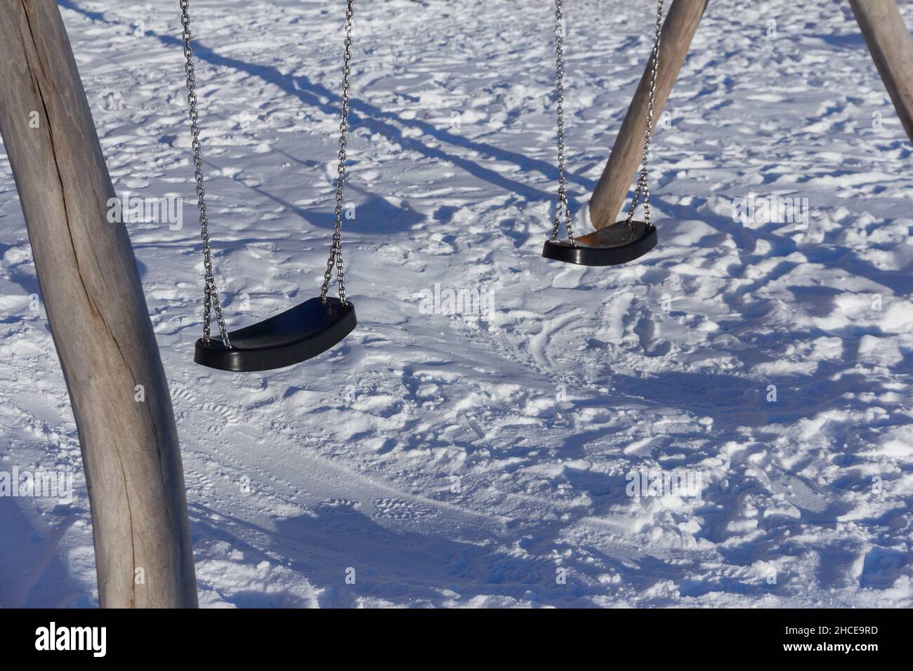 Swing in the playground in winter. Empty swing in winter time. Winter ...
