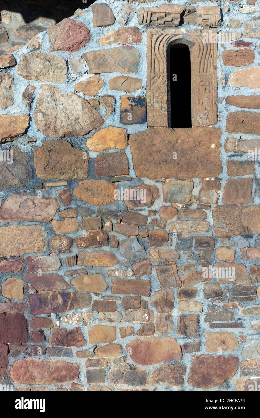 stone wall of an ancient church with romanic symbols on a window Stock ...